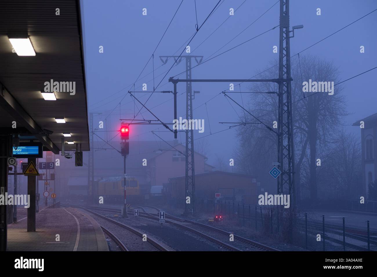 German Railways, a station on a foggy early morning at dawn. The red ...