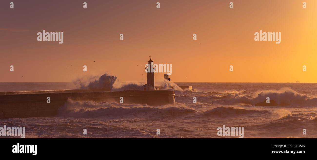 A lighthouse and a concrete pier on the shore of a raging ocean. Huge ...