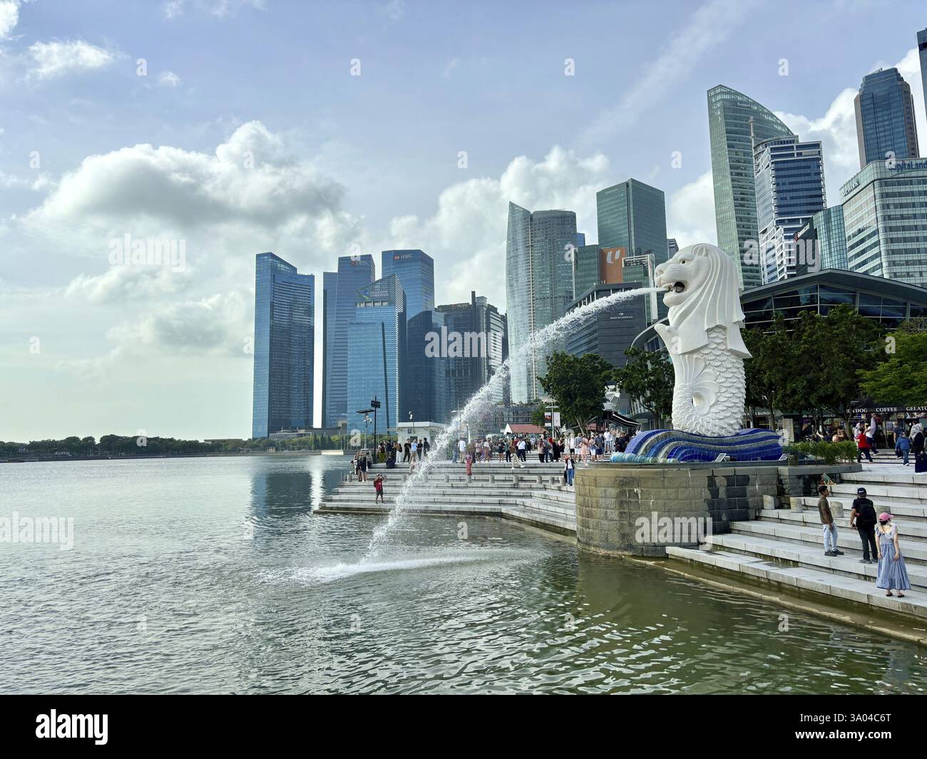 Merlion fountain spouts water in front of the impressive skyline and ...