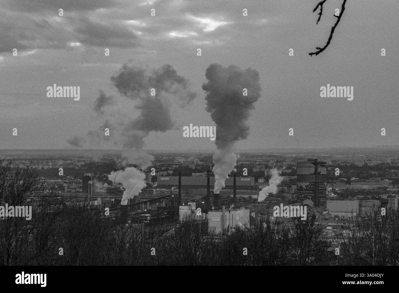 Black and white cloudy winter view from hill for city and factories in ...