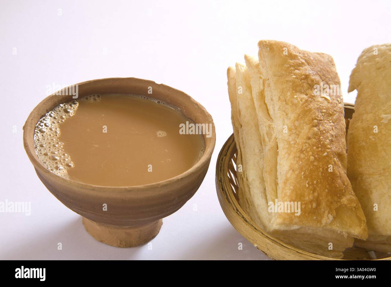 Breakfast hot drink tea in earthen pot and khari biscuits in cane ...