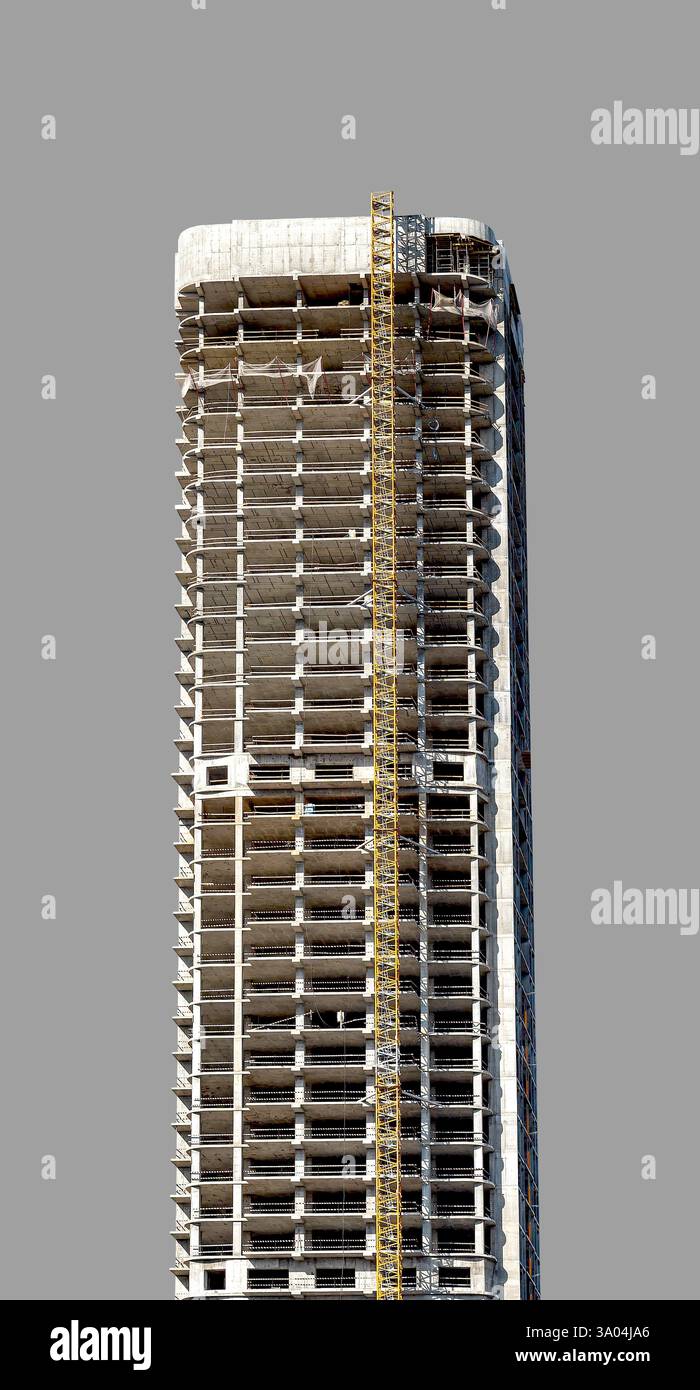 Under construction tall skyscraper in downtown city. Unfinished facade ...