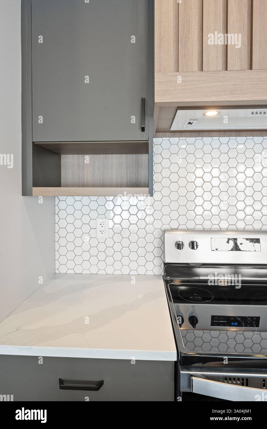 Kitchen with a white tile backsplash and a black stove. The stove has a ...