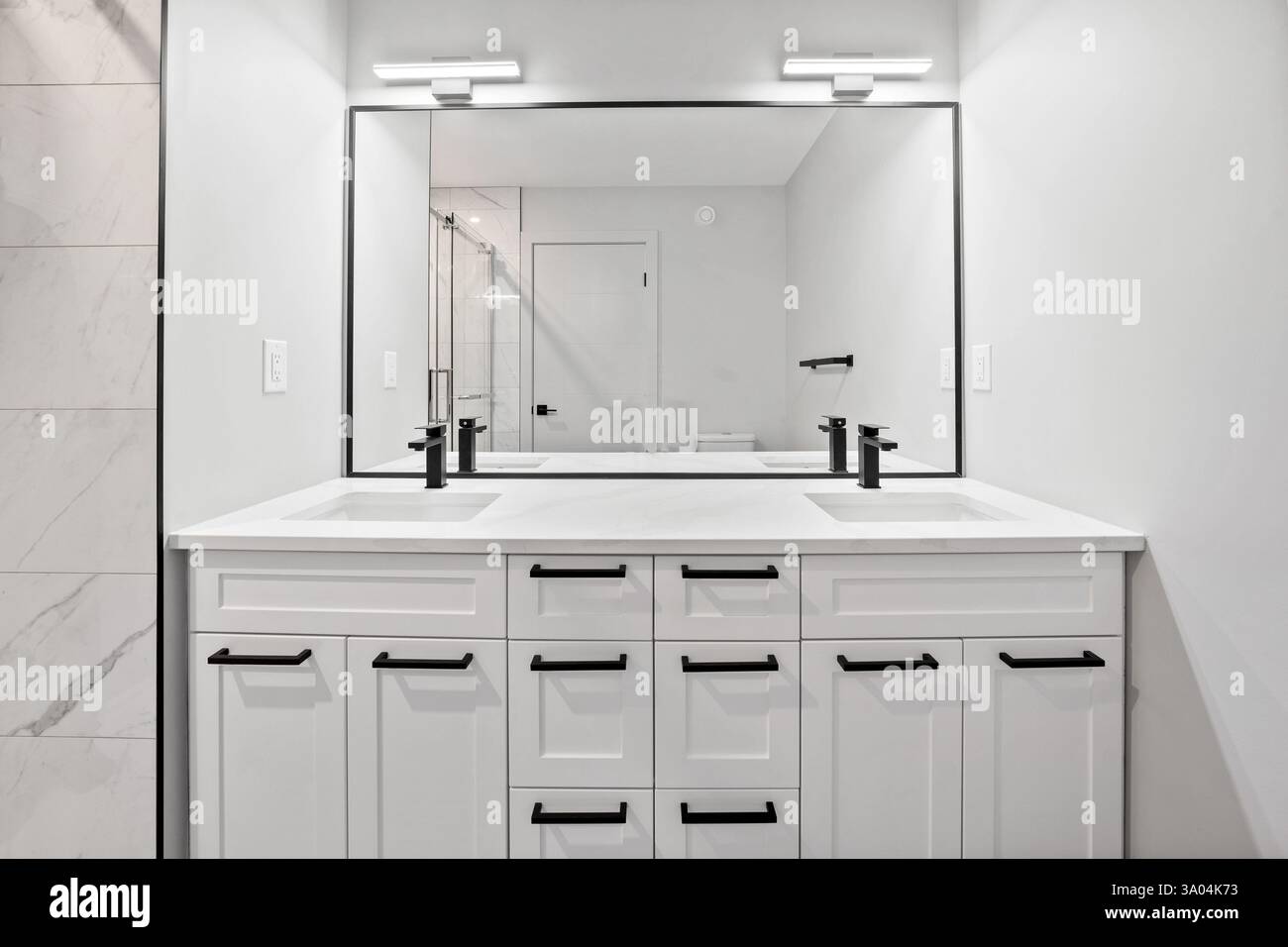 The bathroom is very clean and well-lit. The mirror is large and the ...