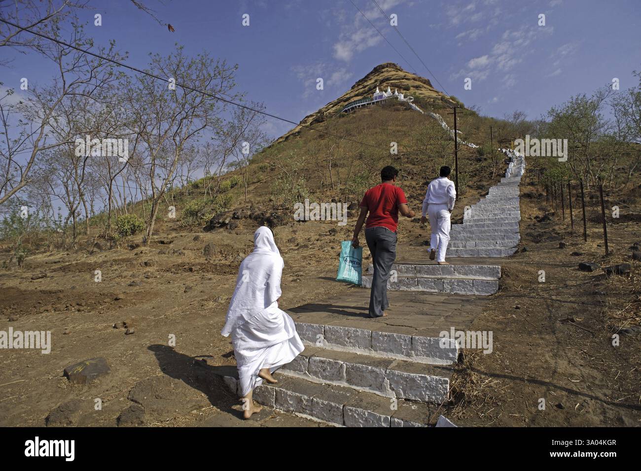 Devotee climbing stair of cave temple digambar Jain Gajpanth Pahad ...