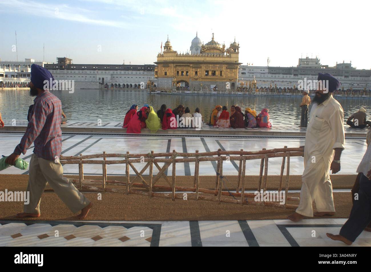 Sikh sitting on the marble steps of Amrit sarovar the lake of nectar ...