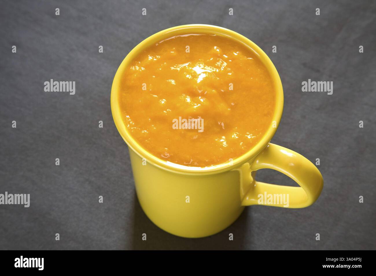 Fruits, mango pulp mangifera indica served in mug on black background ...