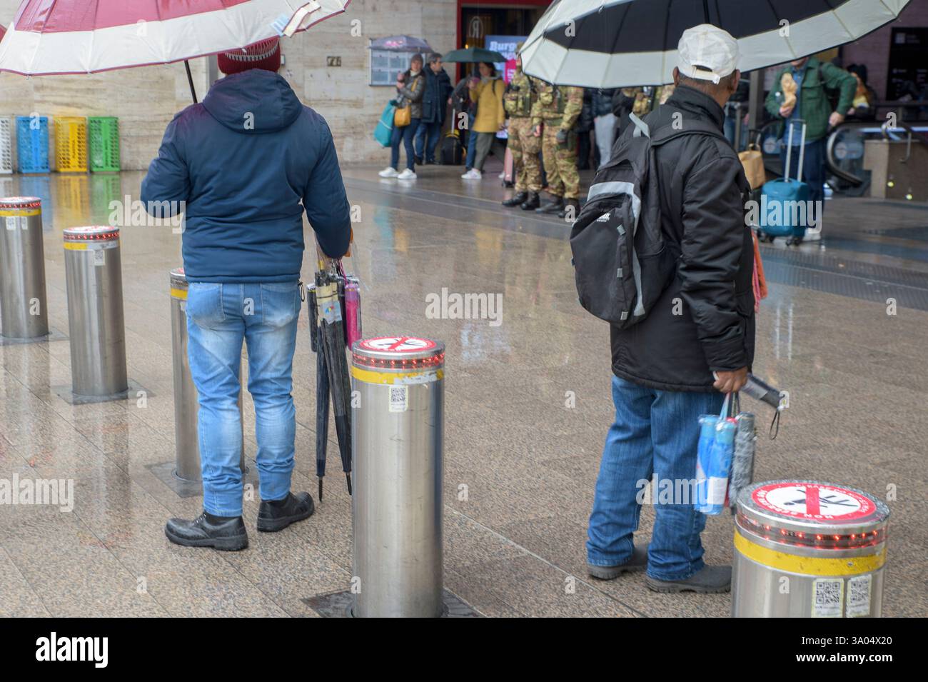March 1, 2025, Rome, Italy: Umbrella vendors wait for passing travelers ...