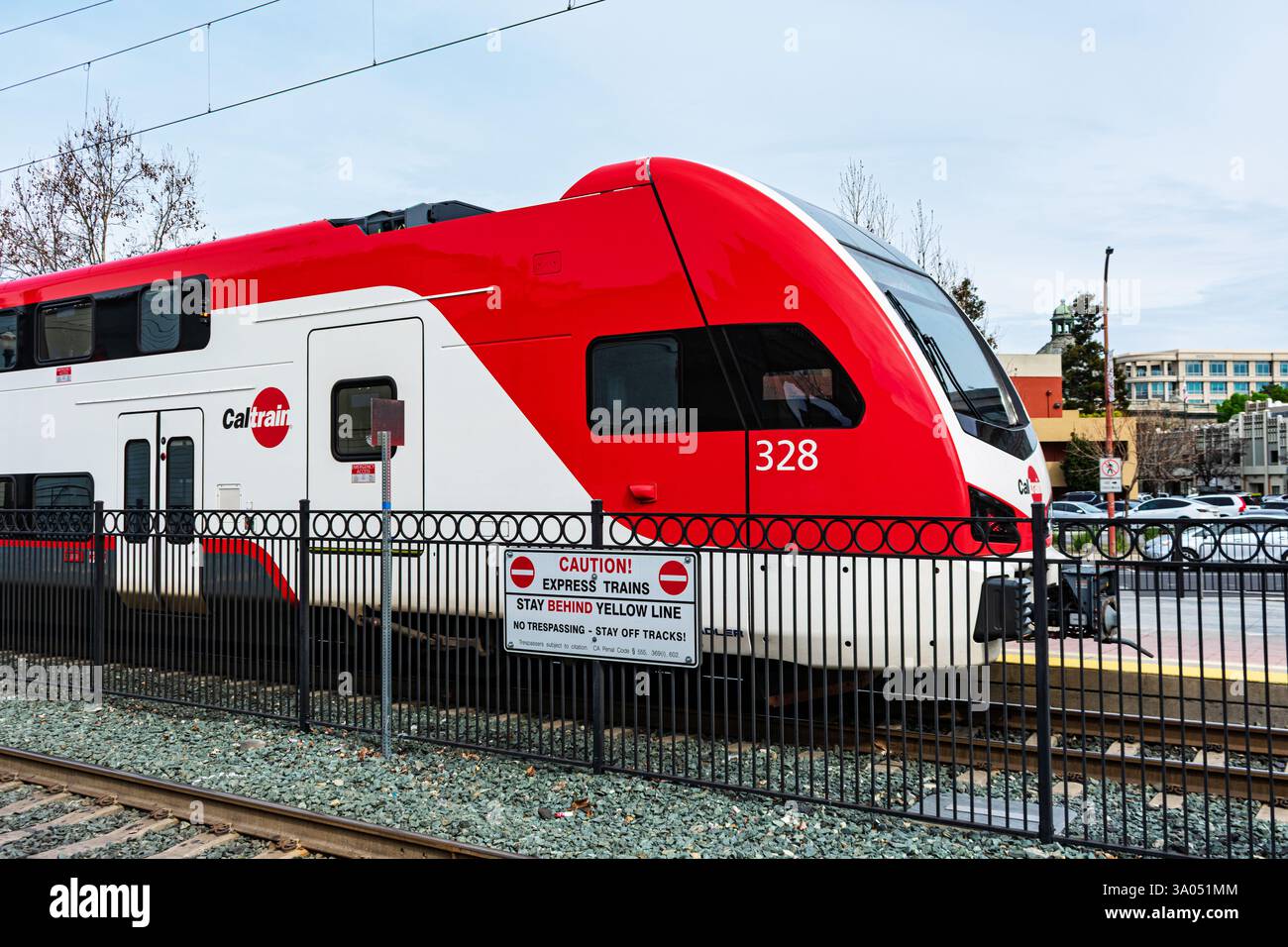 Red and white Caltrain train labeled 328 is parked at a station ...