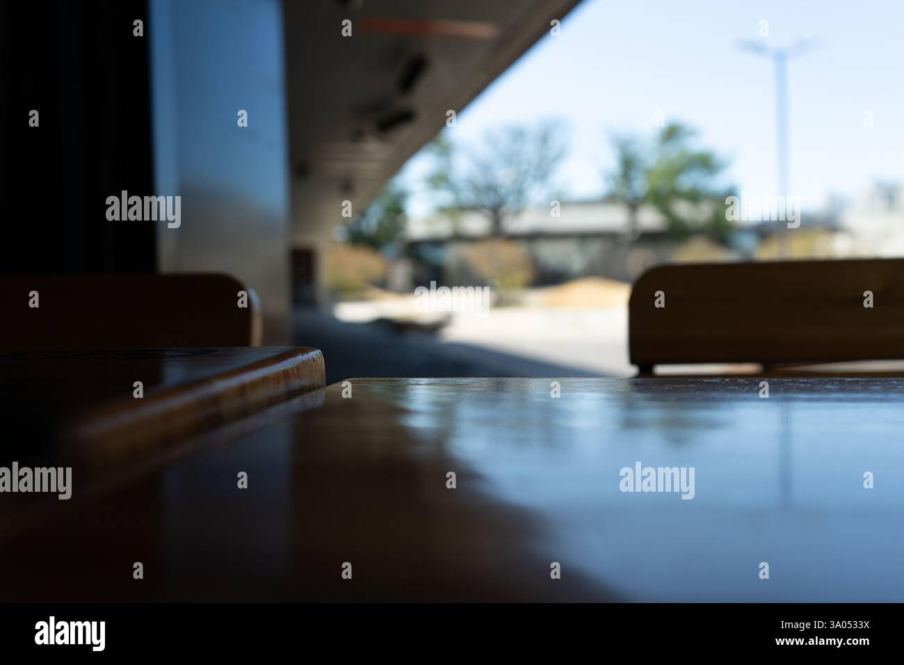 Polished wooden table surface gleaming in sunlight at an outdoor cafe ...