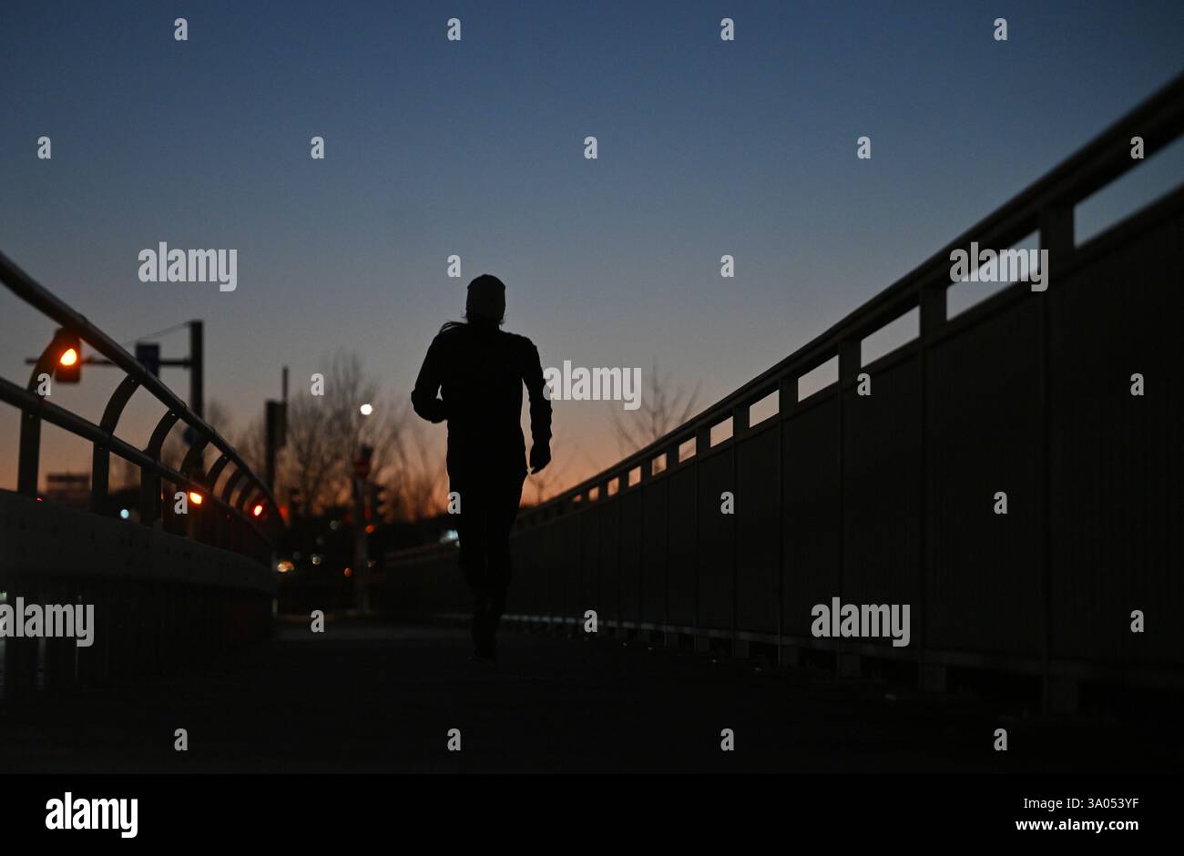 02 March 2025, Baden-Württemberg, Stuttgart: A woman jogs across a ...