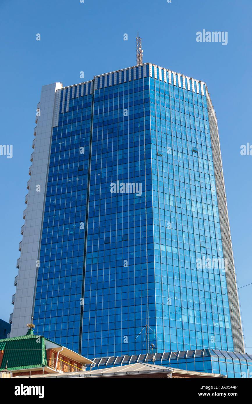 Blue glass skyscraper rising into a vibrant blue sky, showcasing modern ...