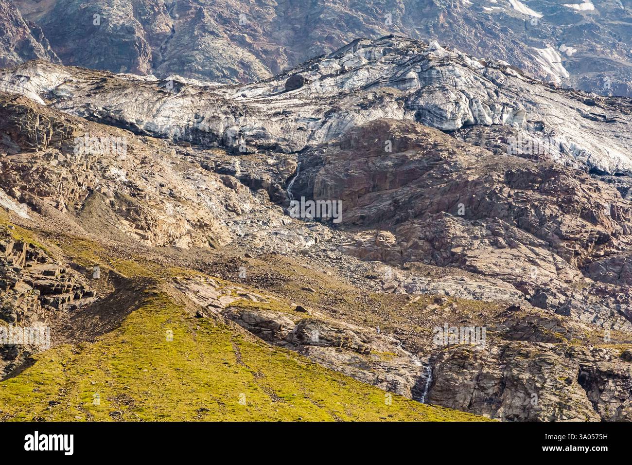 Water flows from a melting glacier, creating a waterfall that descends ...