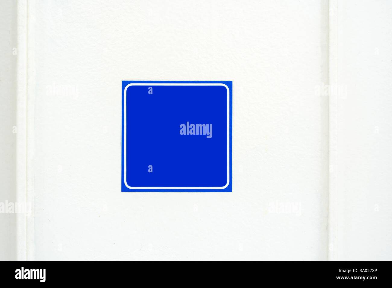Simple minimal empty blank blue square information sign on a white wall ...
