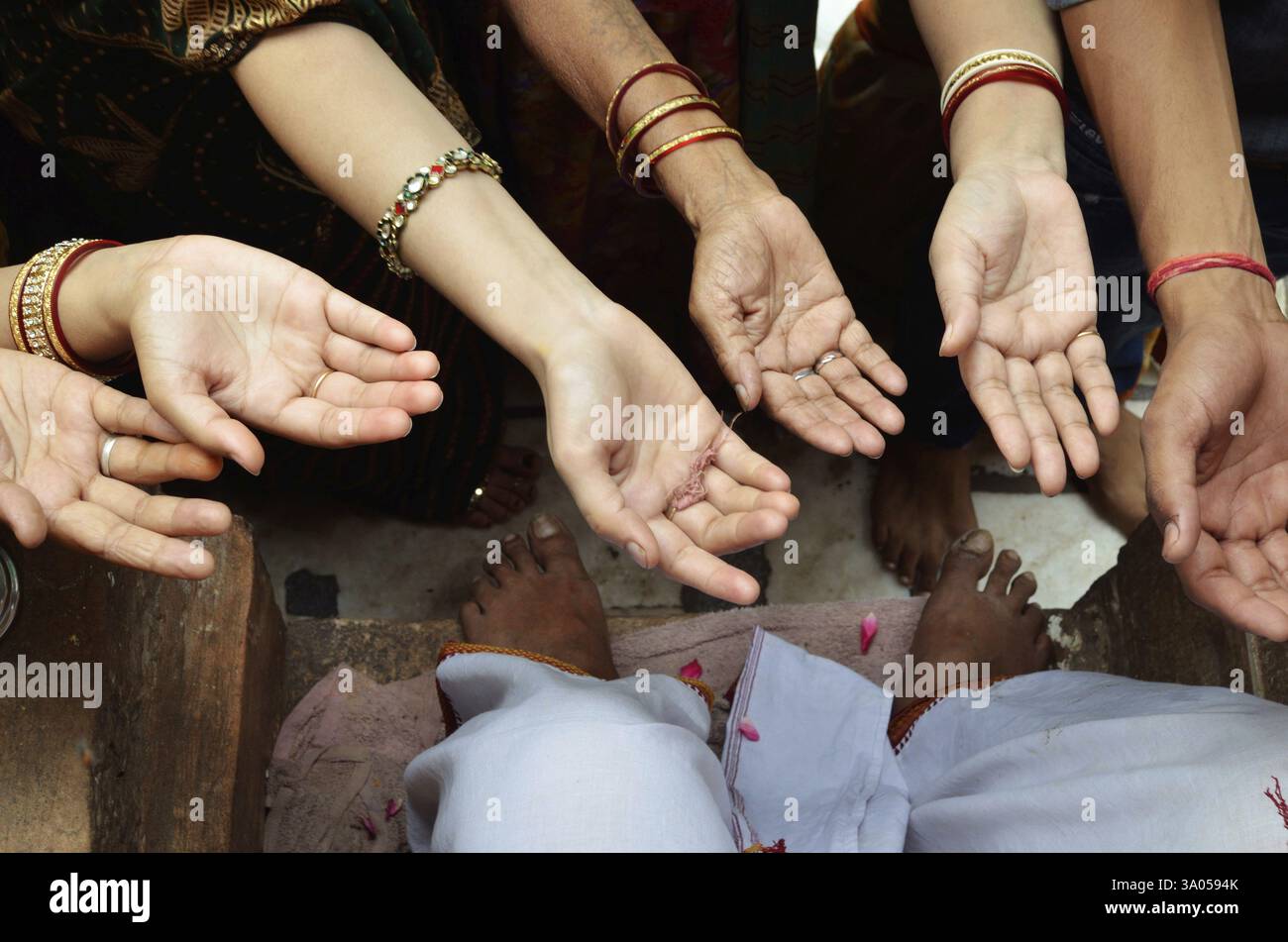 Women spreading hands take sacred thread the priest Achalnath temple ...