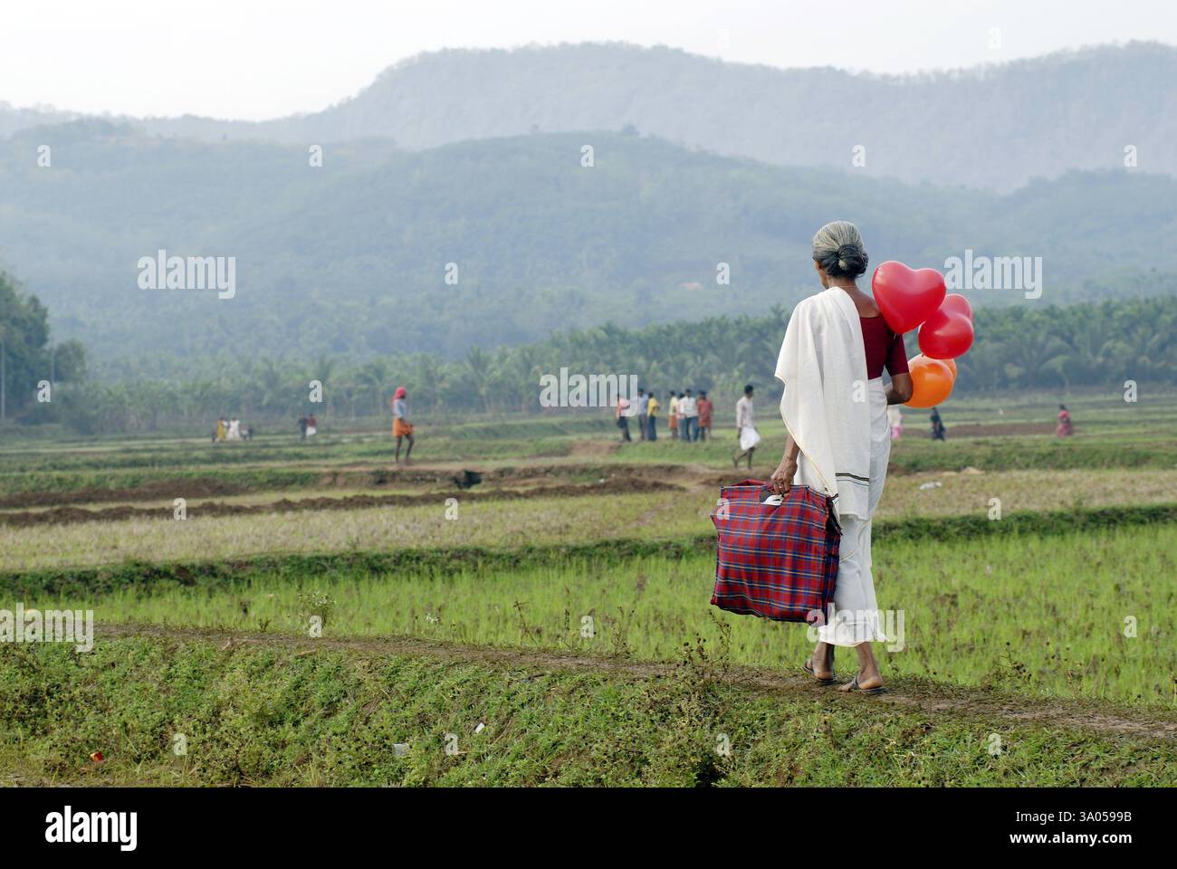 A woman carrying balloons for her grand children, kerala, India, Asia ...