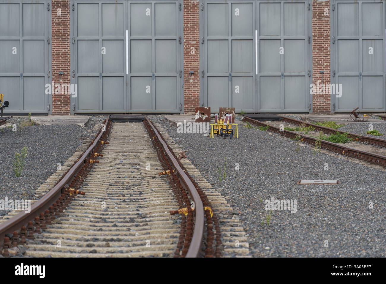 Empty rails lead to large grey doors on gravel, bochum, westphalia, germany Stock Photo - Alamy