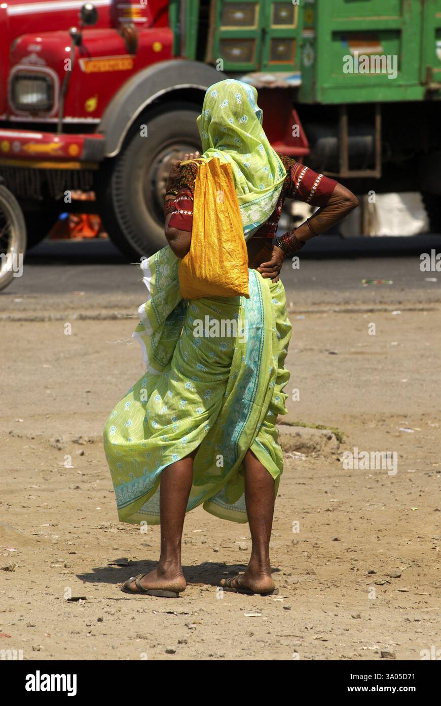 Old woman wearing nine yard sari waiting for bus at village Urli ...