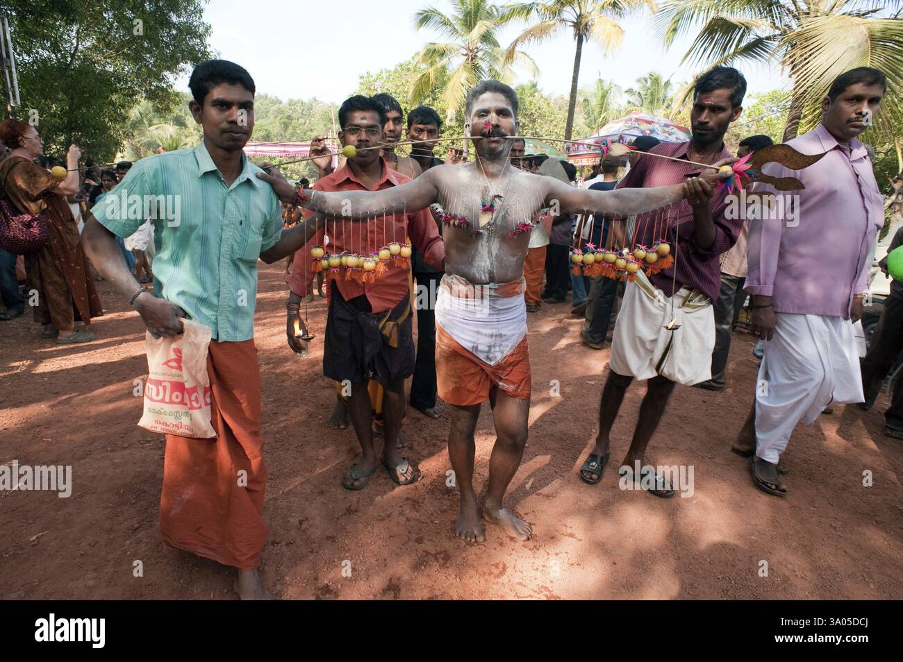 Man piercing spike through cheeks discharging vow in Thaipusam festival ...