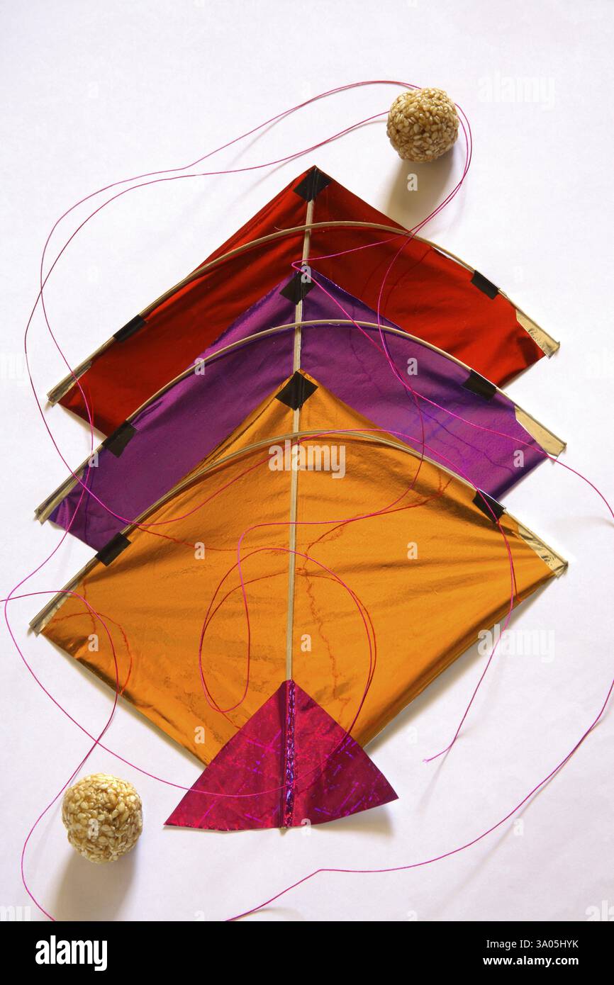 Colourful kites with thread and sweet tilgur or til gul sesame laddoos ...