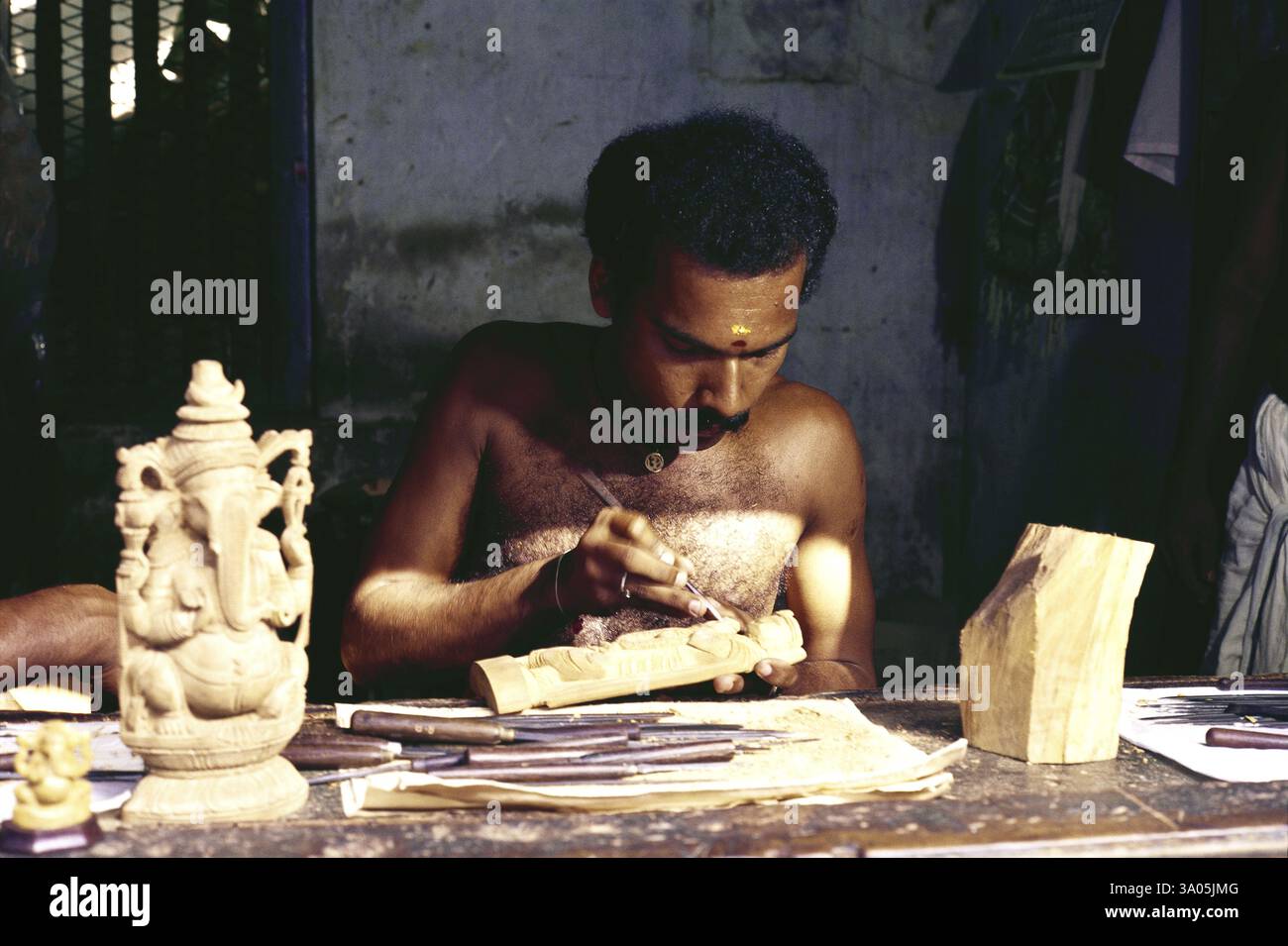Craftsman carving an idol out of sandalwood, traditional Indian ...