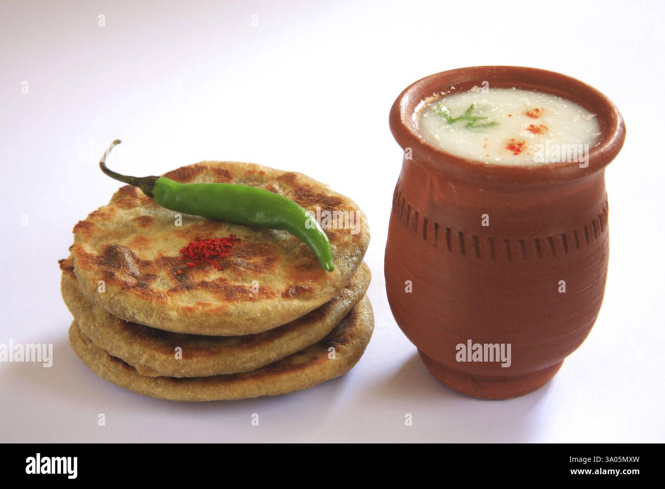 Bhakri jowar bread with green chilli and buttermilk in earthen pot on ...