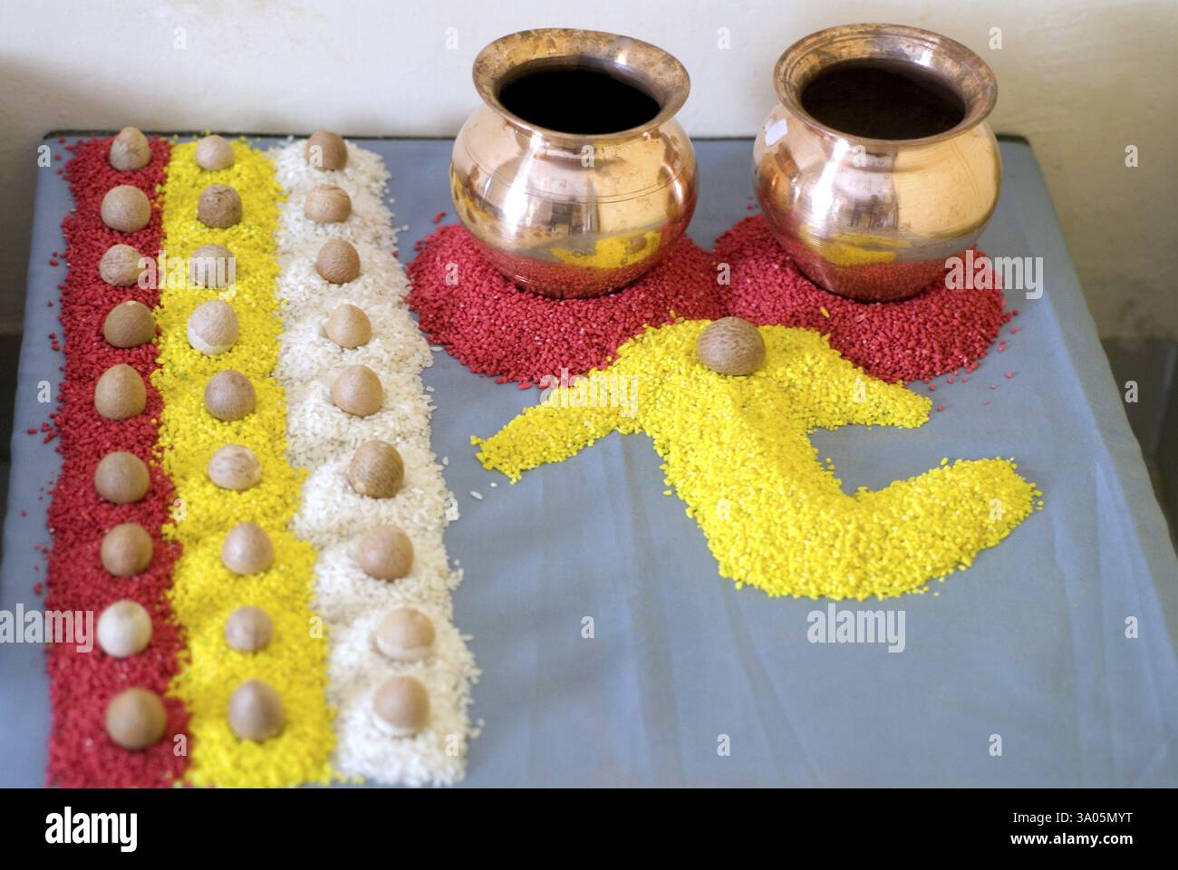 Colourful dyed rice grains betel nuts copper pots kalash icon of lord ...