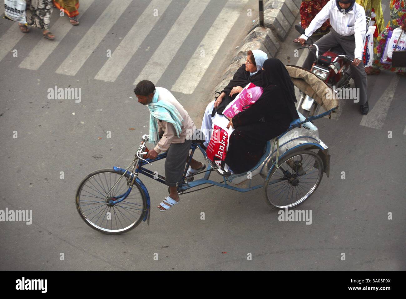 Two women riding on tricycle rickshaw pulled by rickshaw driver in ...