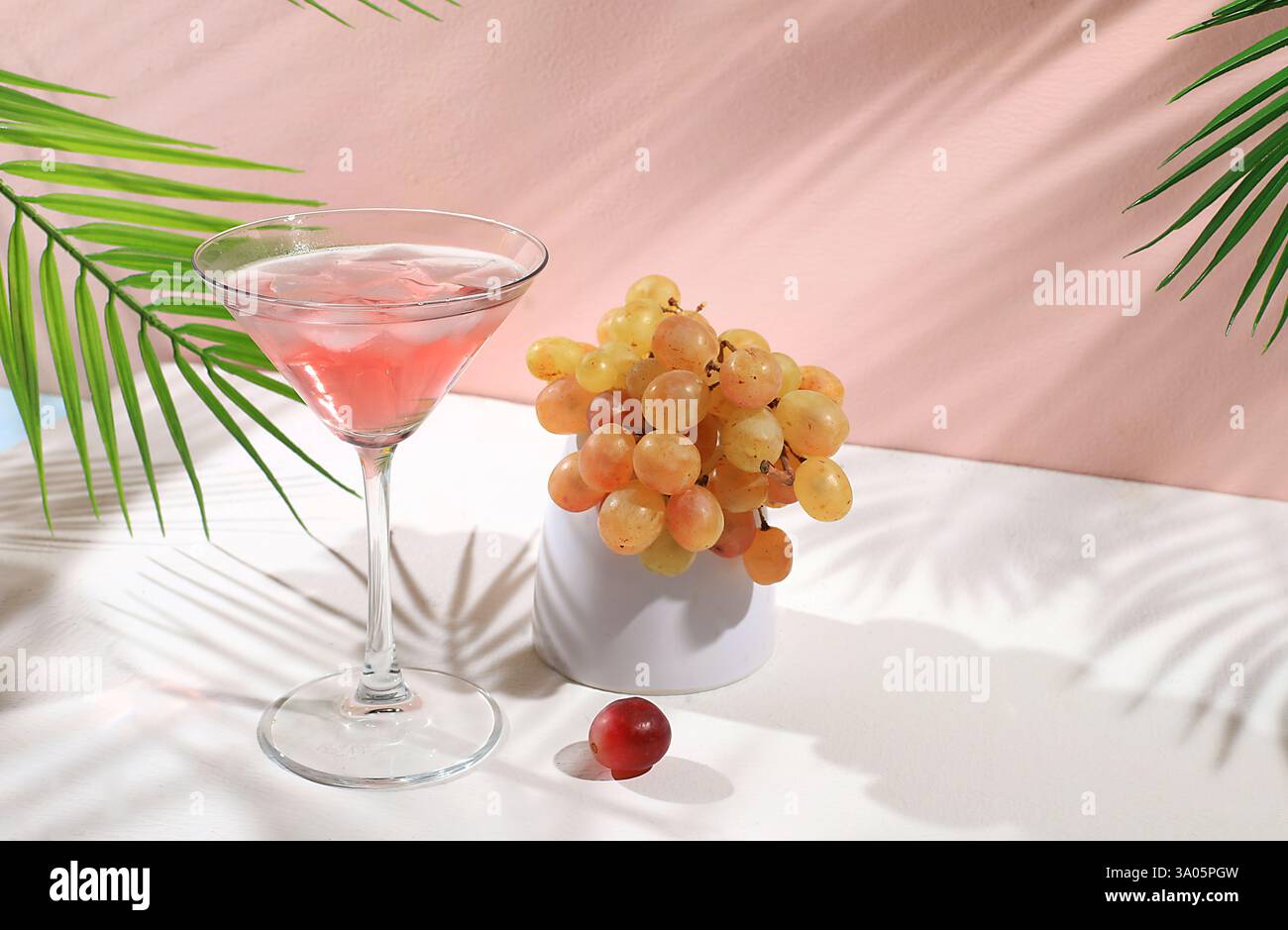 Modern still life with alcoholic margarita cocktail and grapes on ...