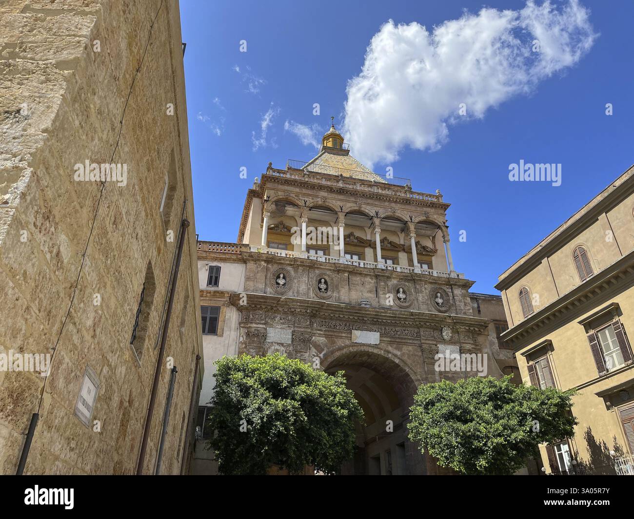 Historic building with high archway and ornate details under a blue sky ...