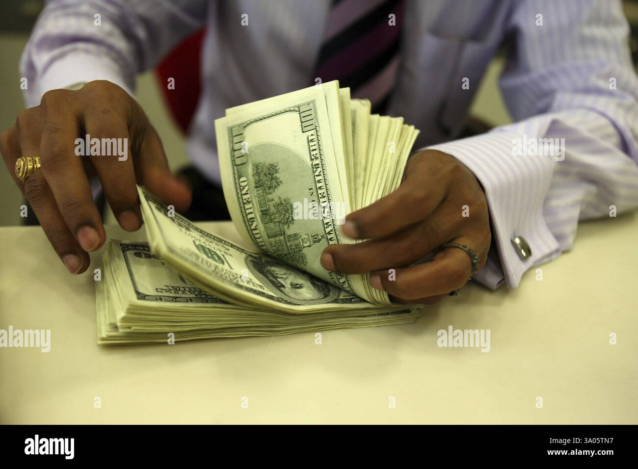 Man counting us dollars Stock Photo - Alamy
