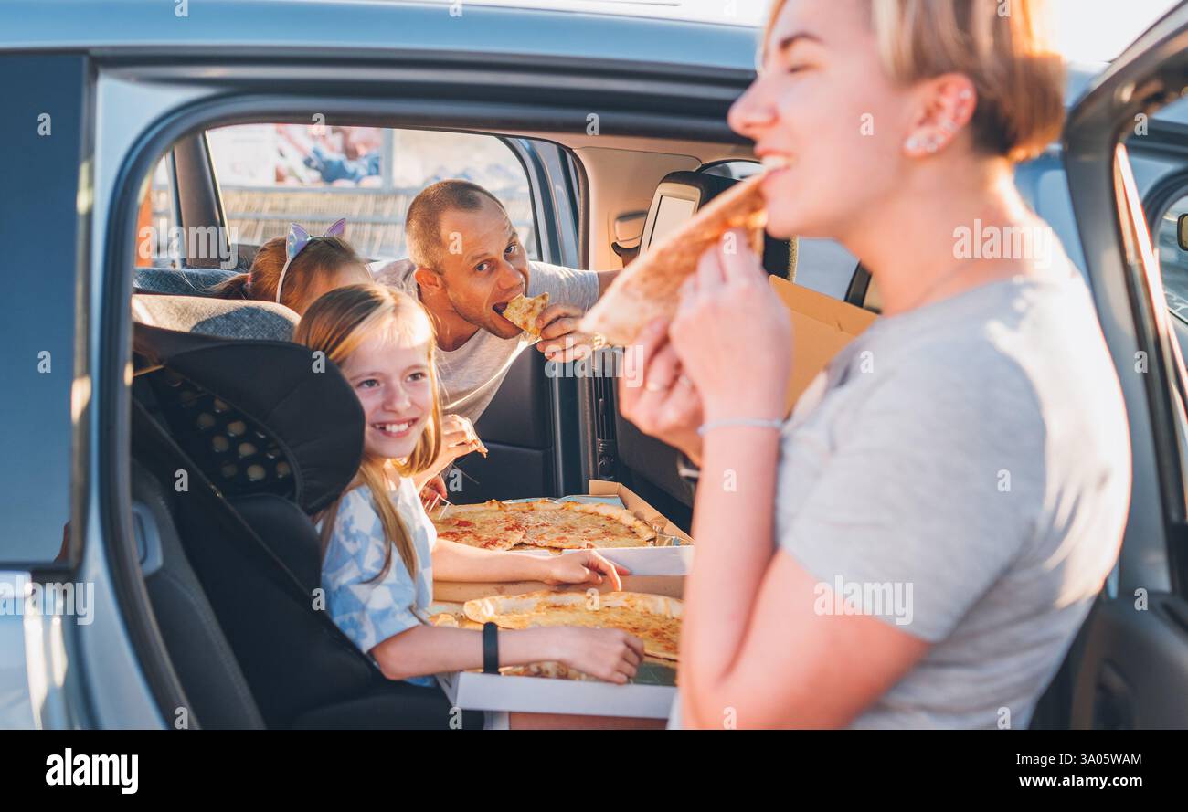 Positive smiling girl in child car seat while family car trip brake ...