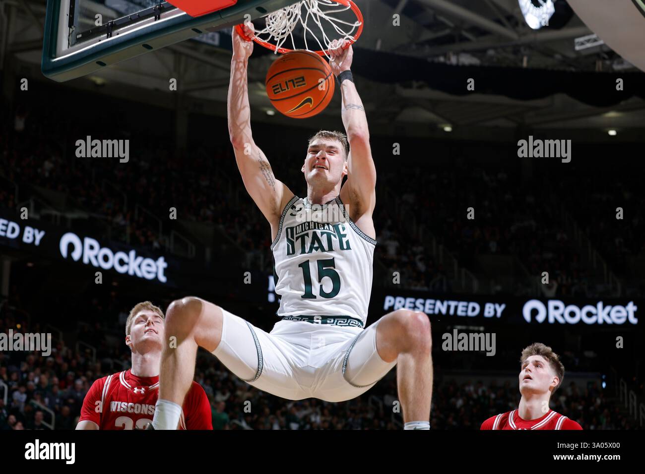 Michigan State center Carson Cooper (15) dunks over Wisconsin forwards ...