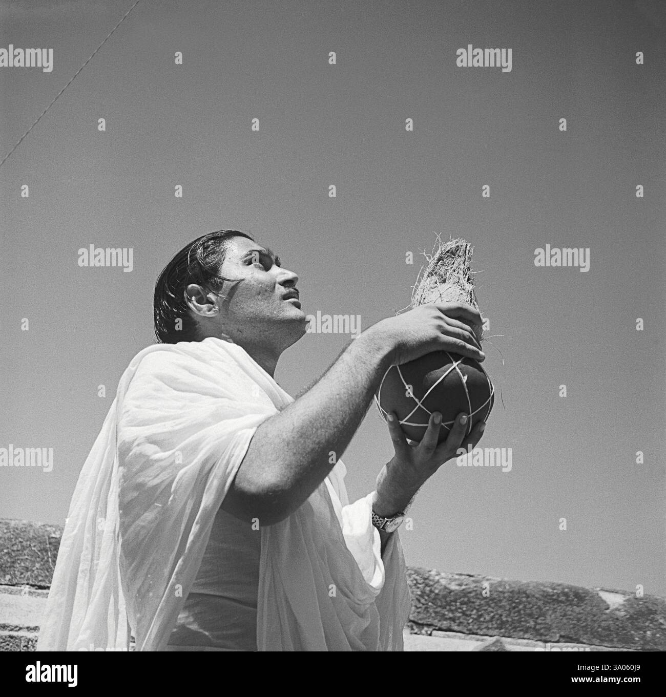 Man holding kalash in front of Gomateshwara (Lord Bahubali), Sacred ...