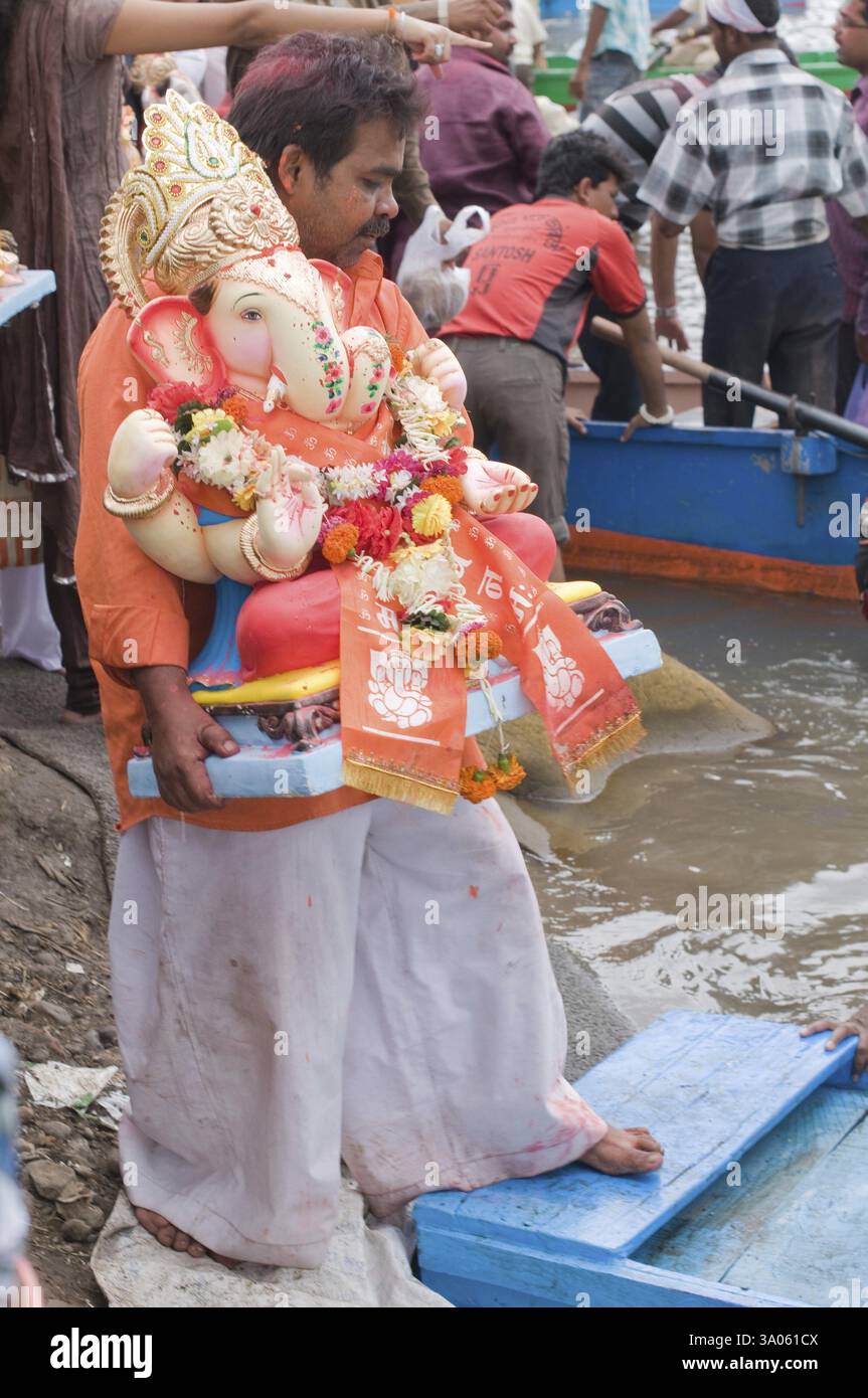 Man carrying idol of Lord Ganesh Pune Maharashtra India Asia Sept 2011 ...