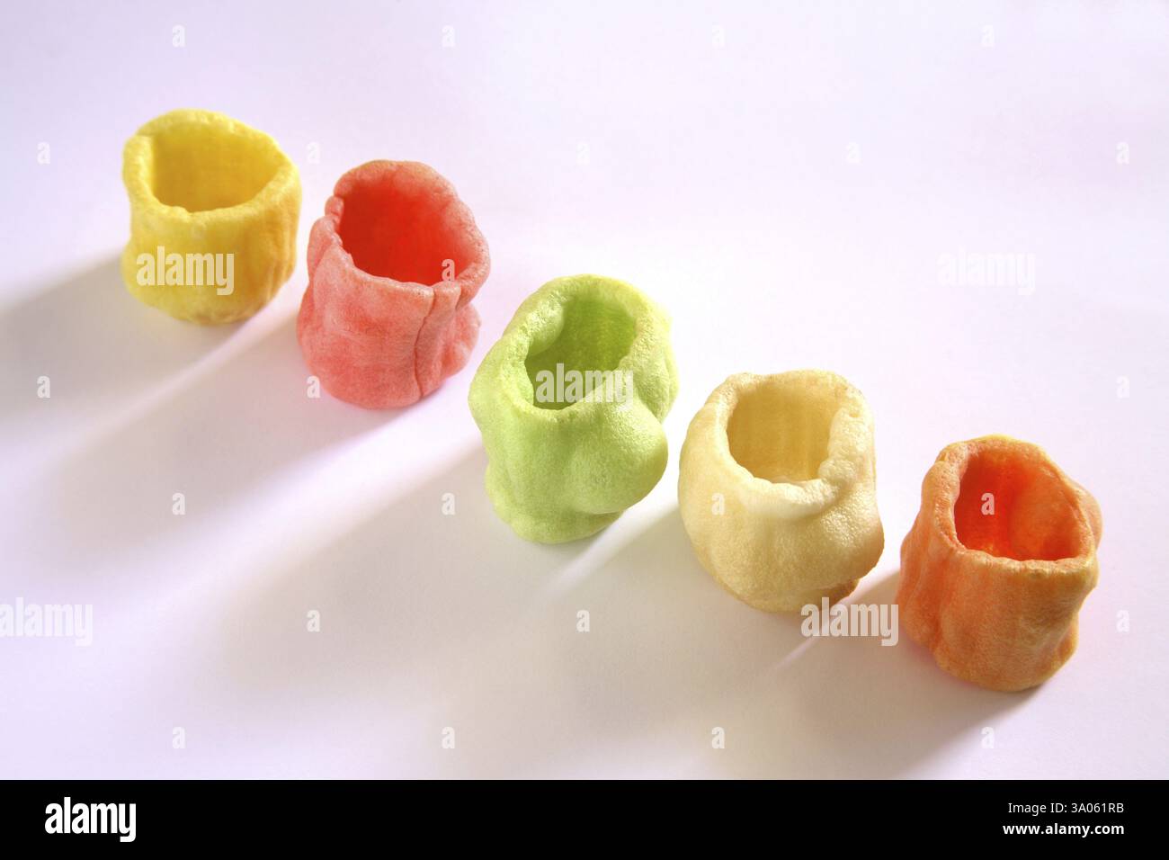 Colourful fried round chips on white background Stock Photo - Alamy