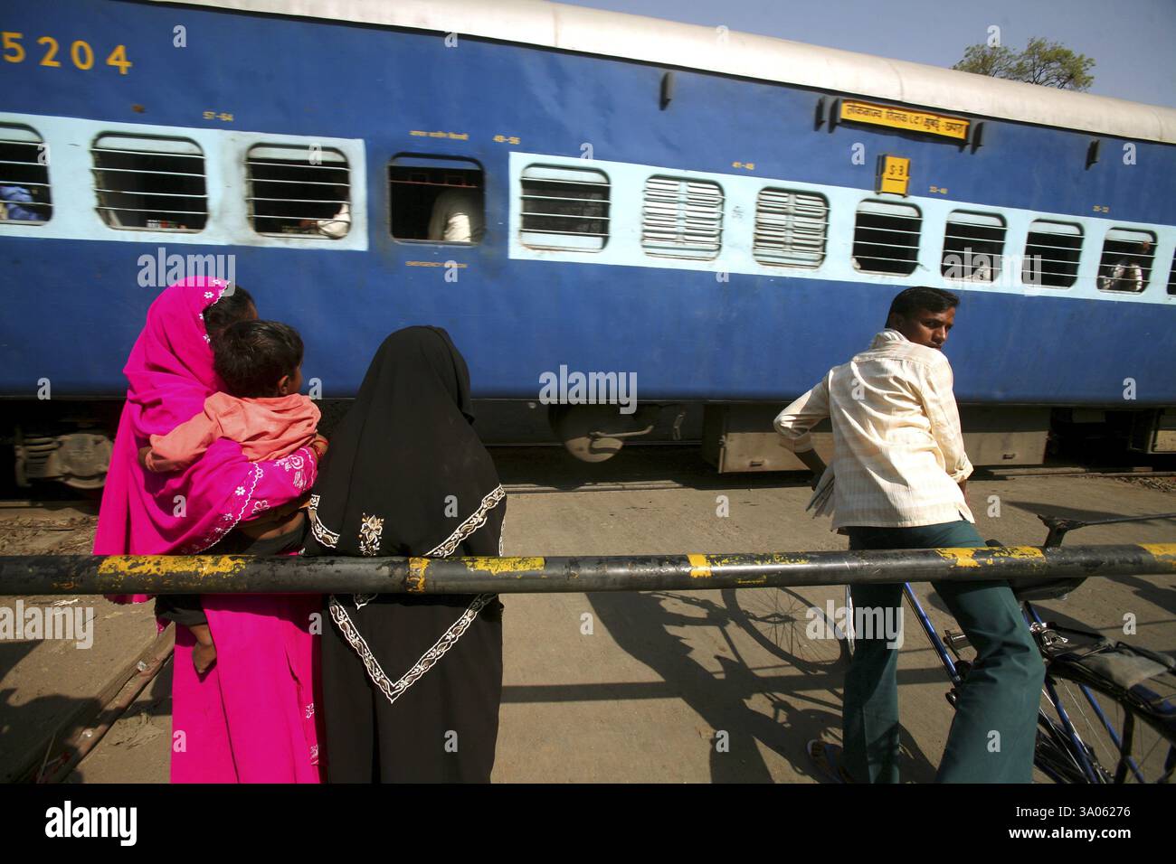 People at railway crossing while Indian railways express train passing ...