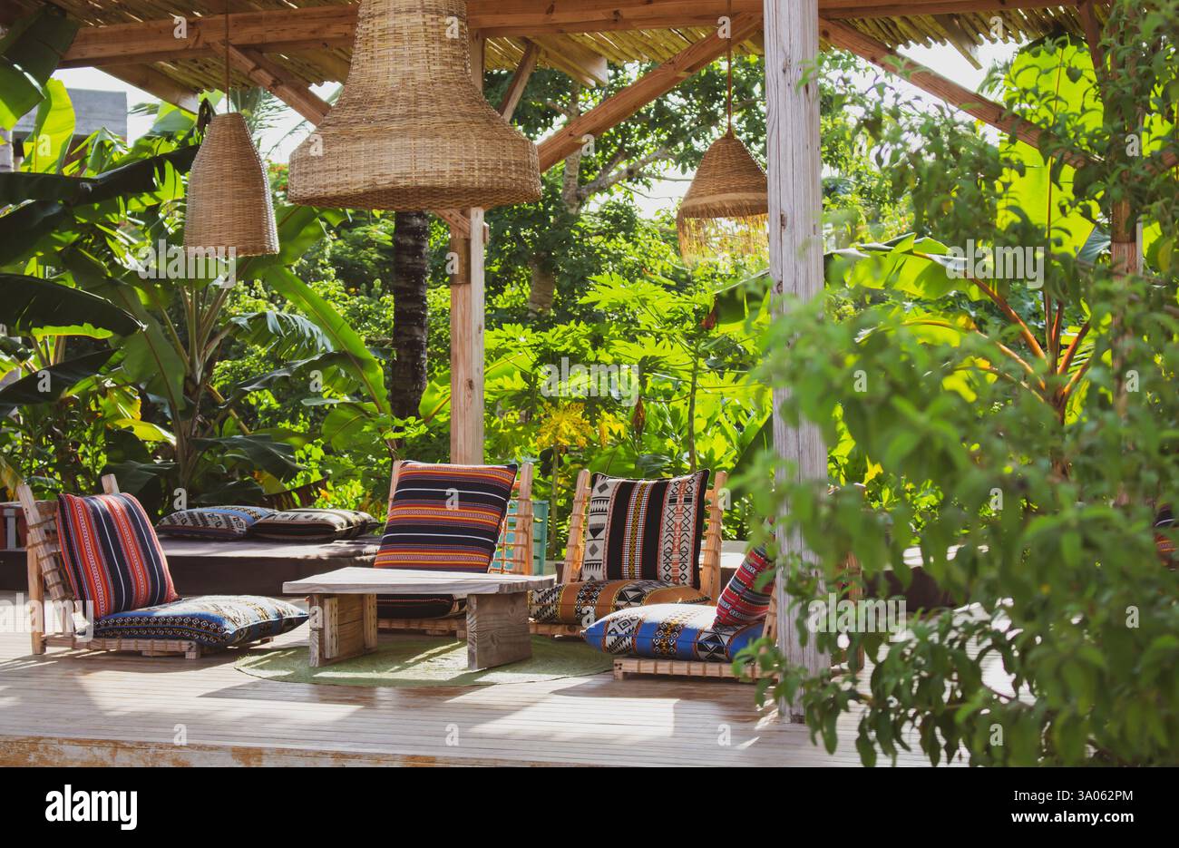 Lounge chairs with pillows and wooden table on the terrace. Cozy patio ...