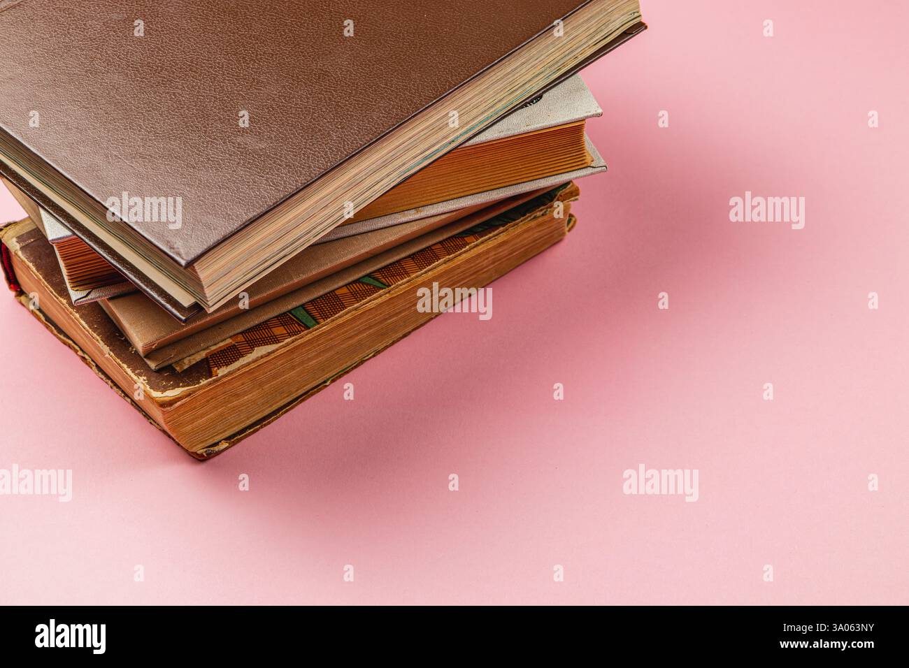 A collection of books in different colors and sizes is stacked on a ...