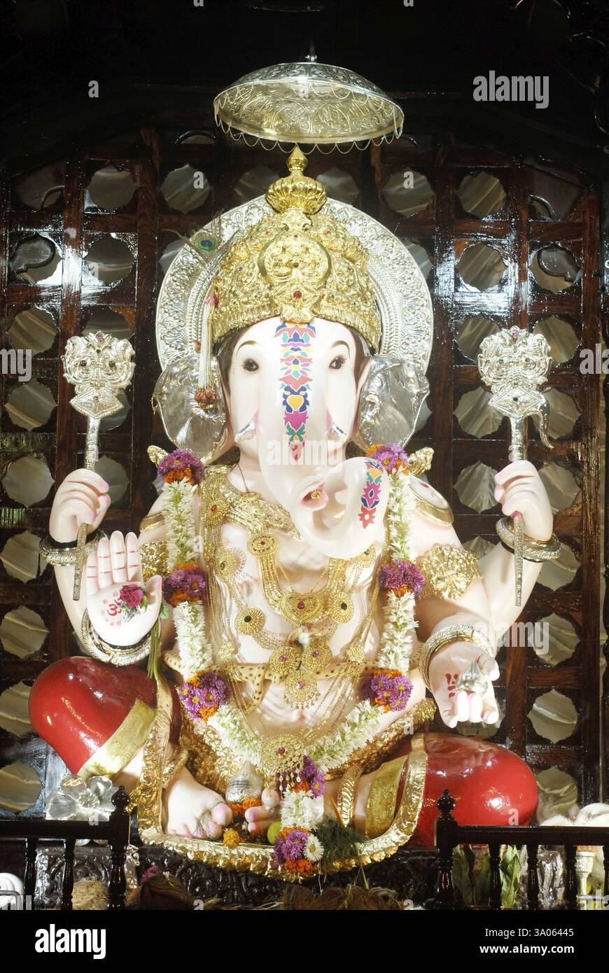 Richly decorated idol of Lord Ganesh kept in gaily decorated frame ...