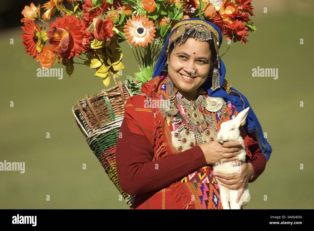 Women in traditional dress holding rabbit at khajjiar, Himachal Pradesh ...
