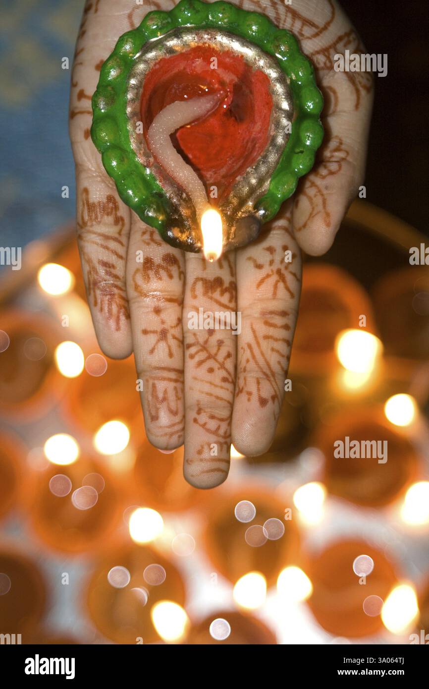 Woman holding diya dip dipak oil lamp on hand, Mehandi Heena pattern ...