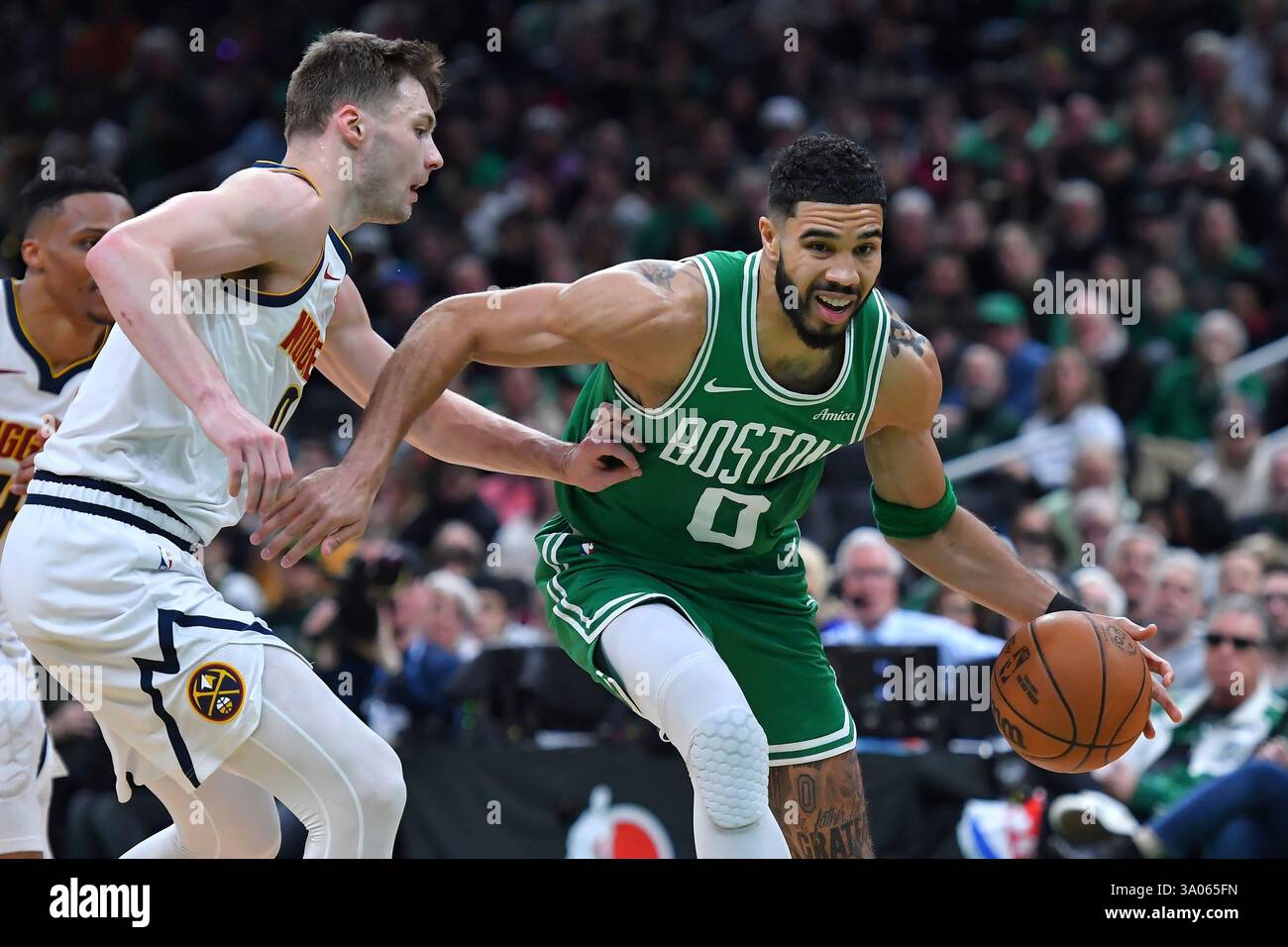 Boston Celtics forward Jayson Tatum, right, drives toward the basket ...
