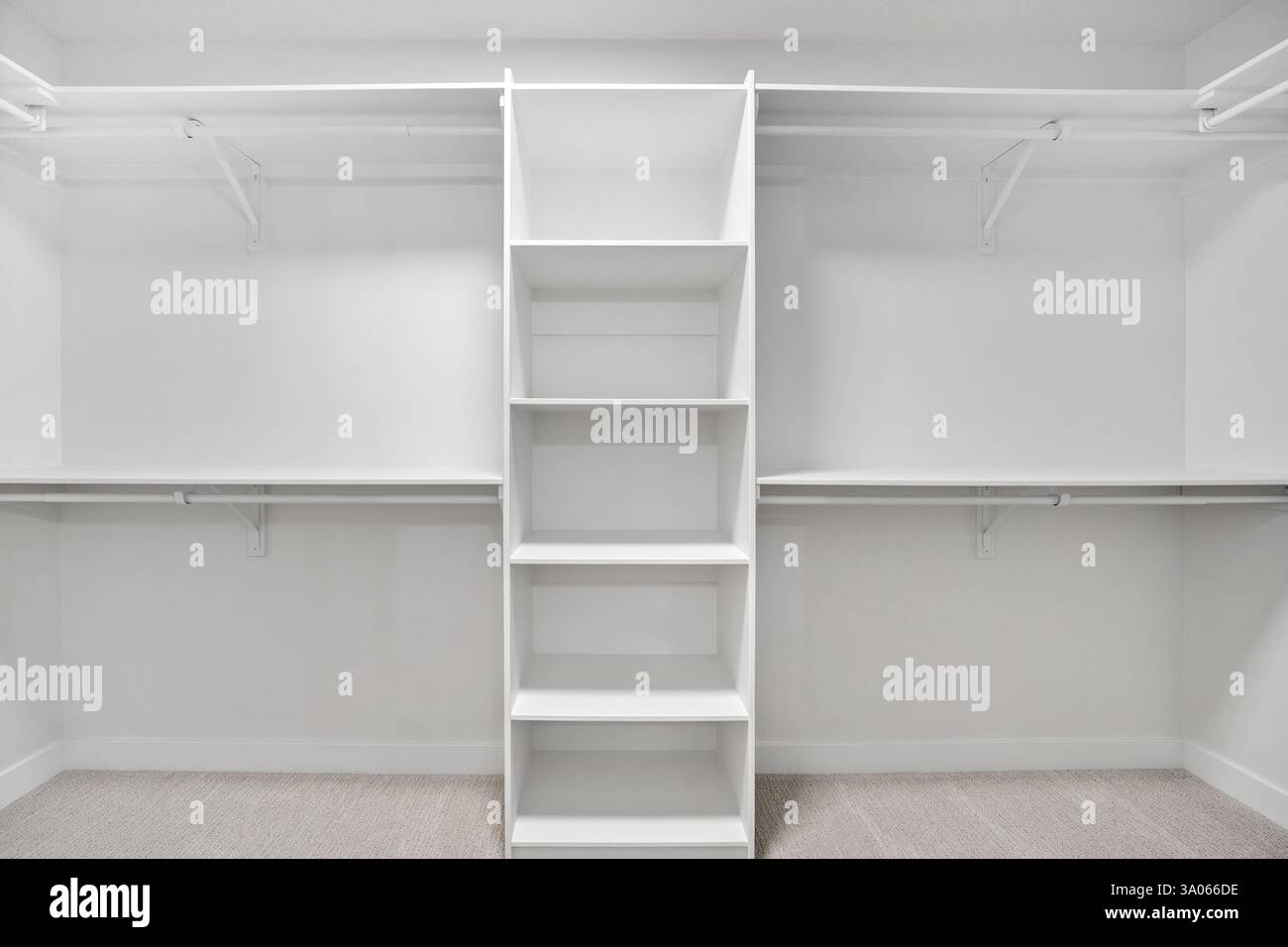 White closet with shelves and racks. The closet is empty and has a ...