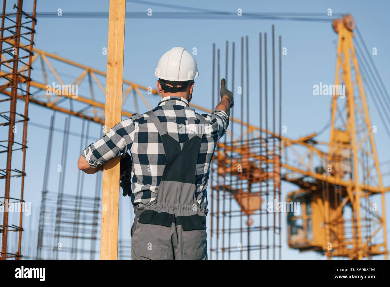 Giving orders to crane operator. Man is working on the construction ...