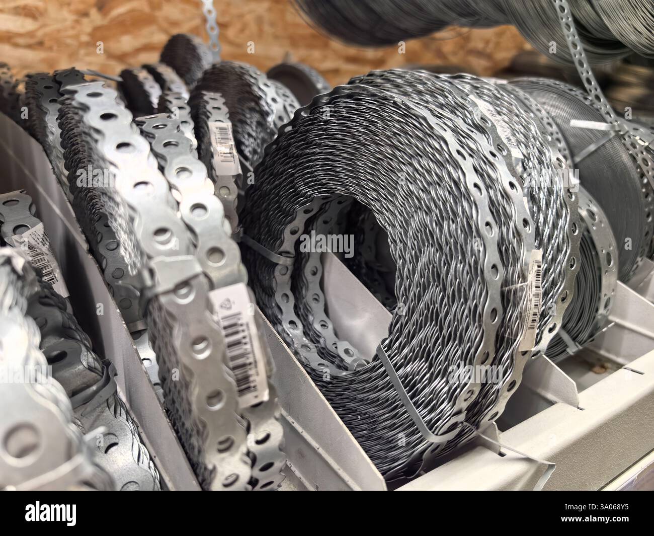 Coils of shiny steel wire rest on display in a well-organized storage ...