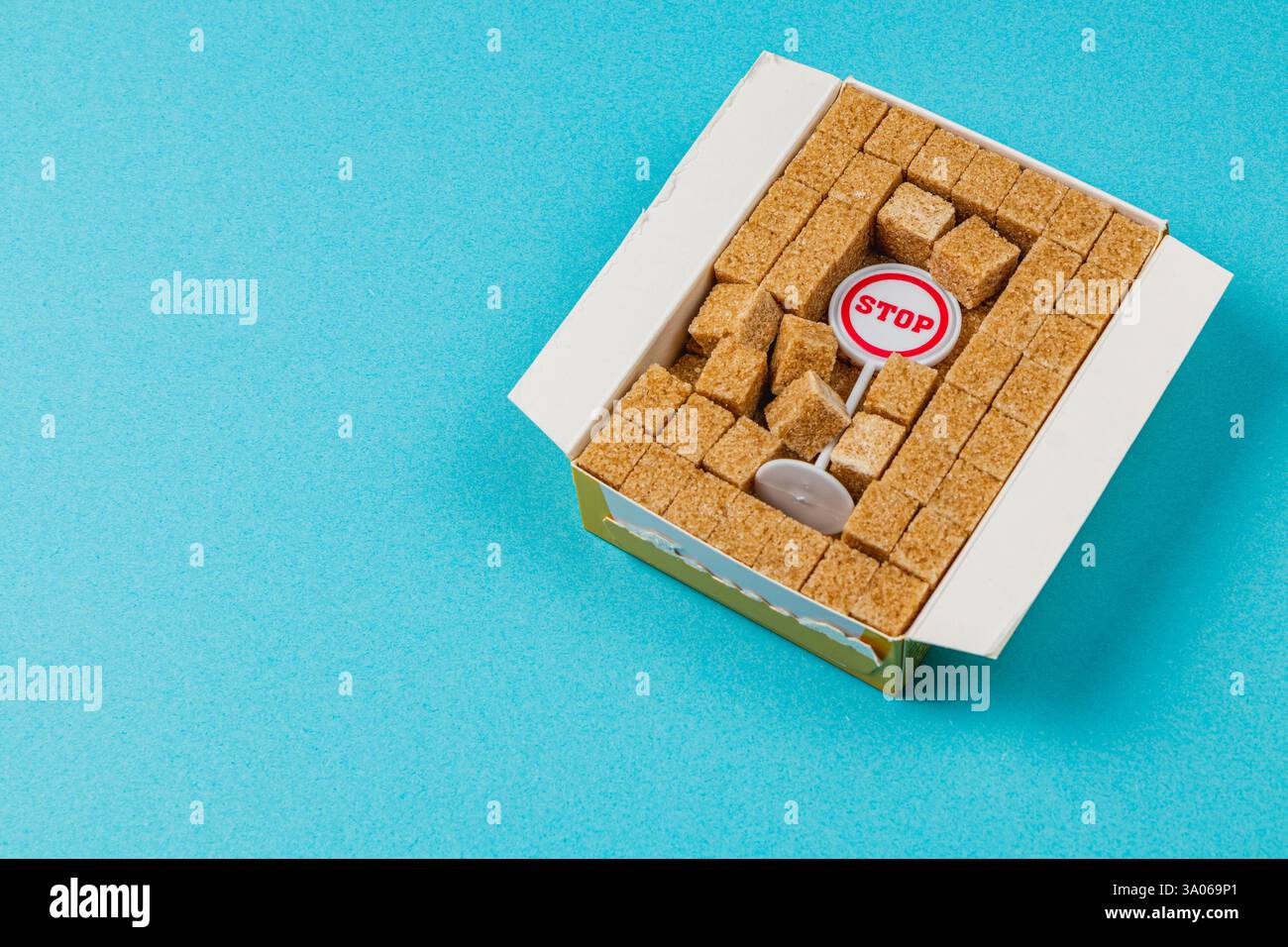 A yellow box filled with brown sugar cubes features a prominent stop ...