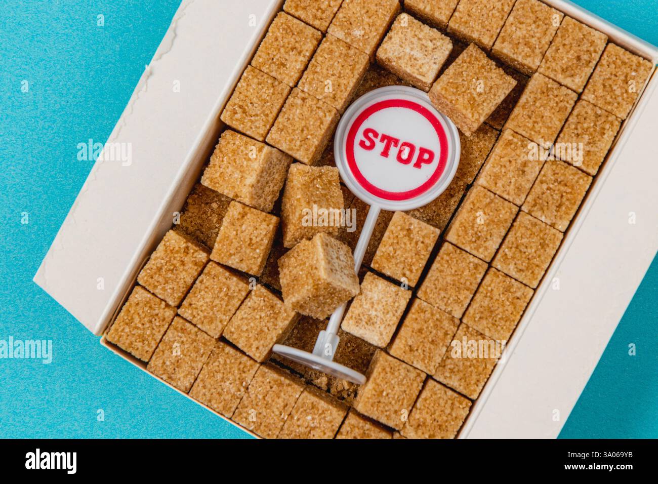 A collection of brown sugar cubes fills a square box, with a playful ...