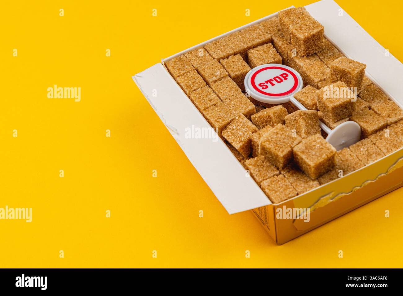 A small box is filled with brown sugar cubes arranged neatly. A round ...