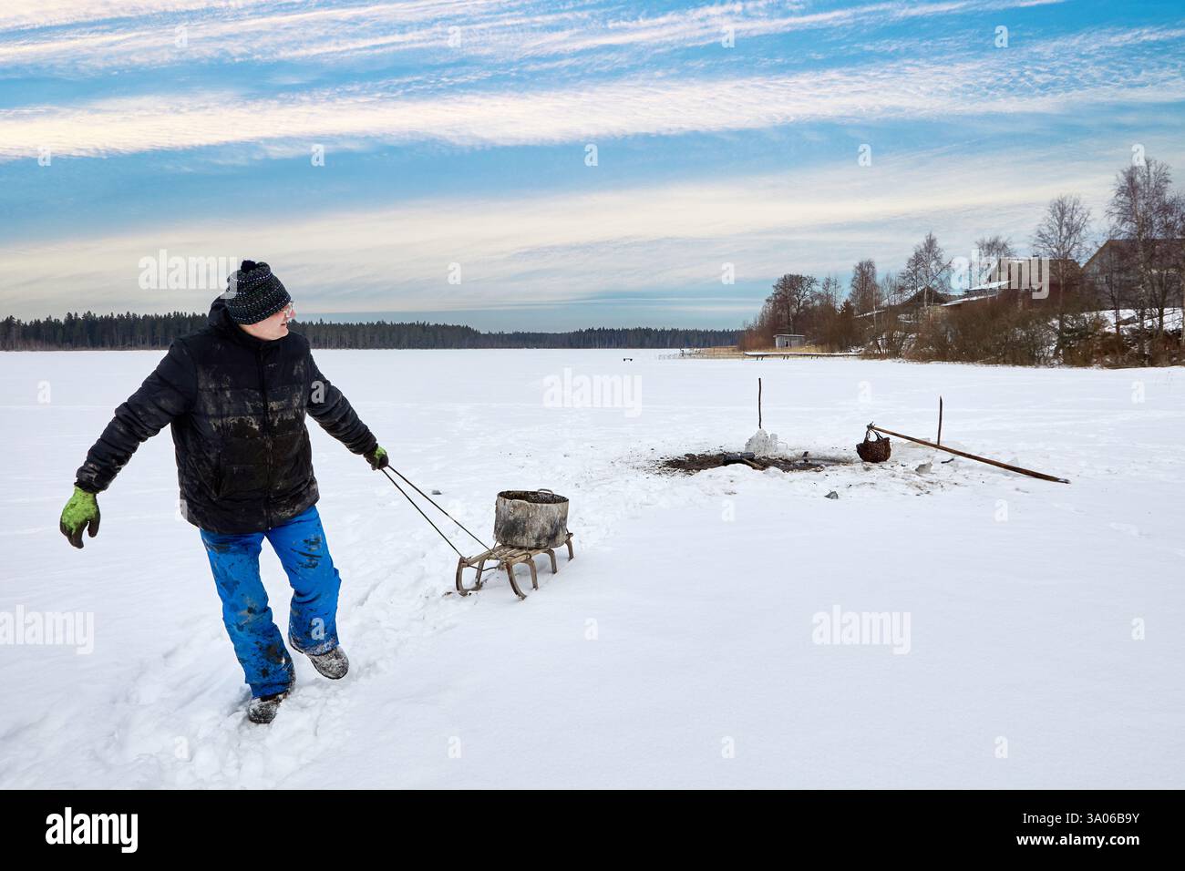 From frozen lake, farmer performs sapropel mining, using pole to scoop ...